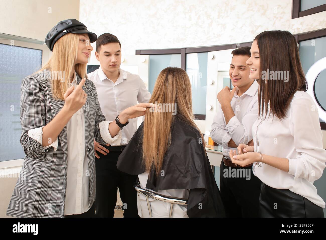 Professional hairdresser teaching young people in salon Stock Photo - Alamy