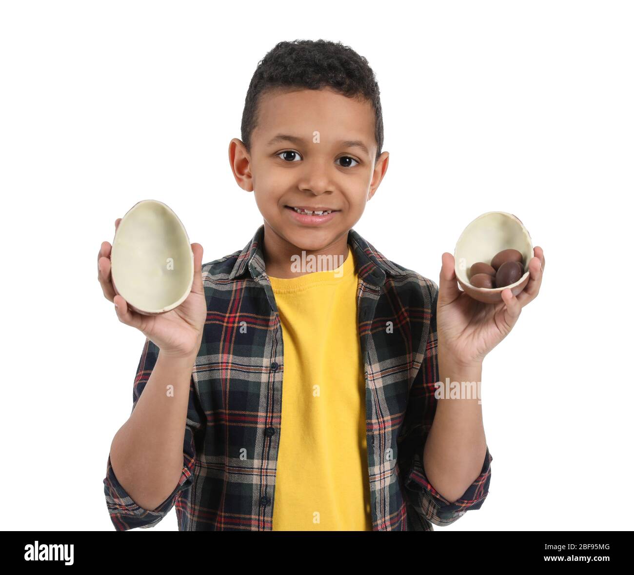 Cute African-American boy with sweet chocolate eggs on white background ...