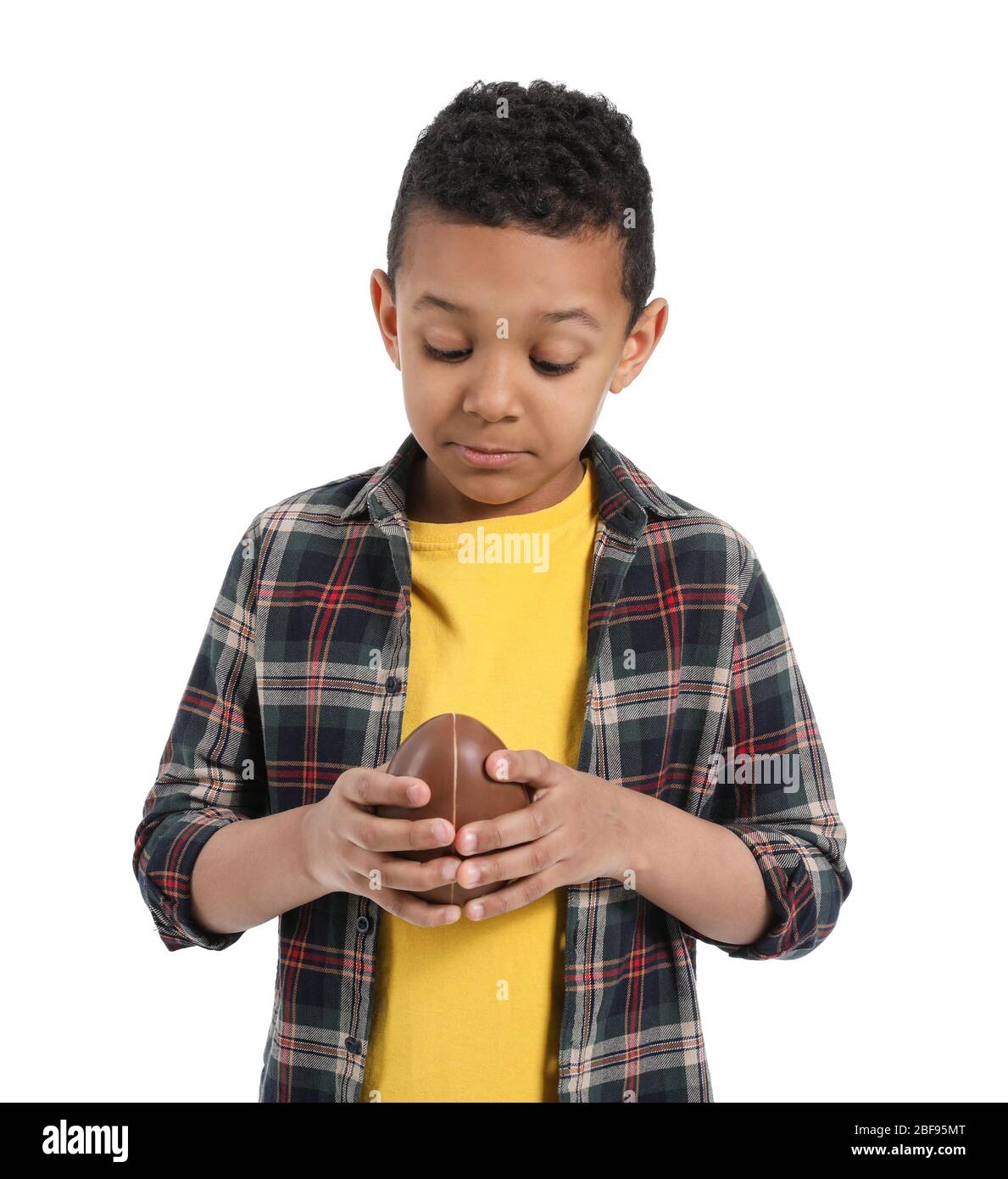Cute African-American boy with sweet chocolate egg on white background ...