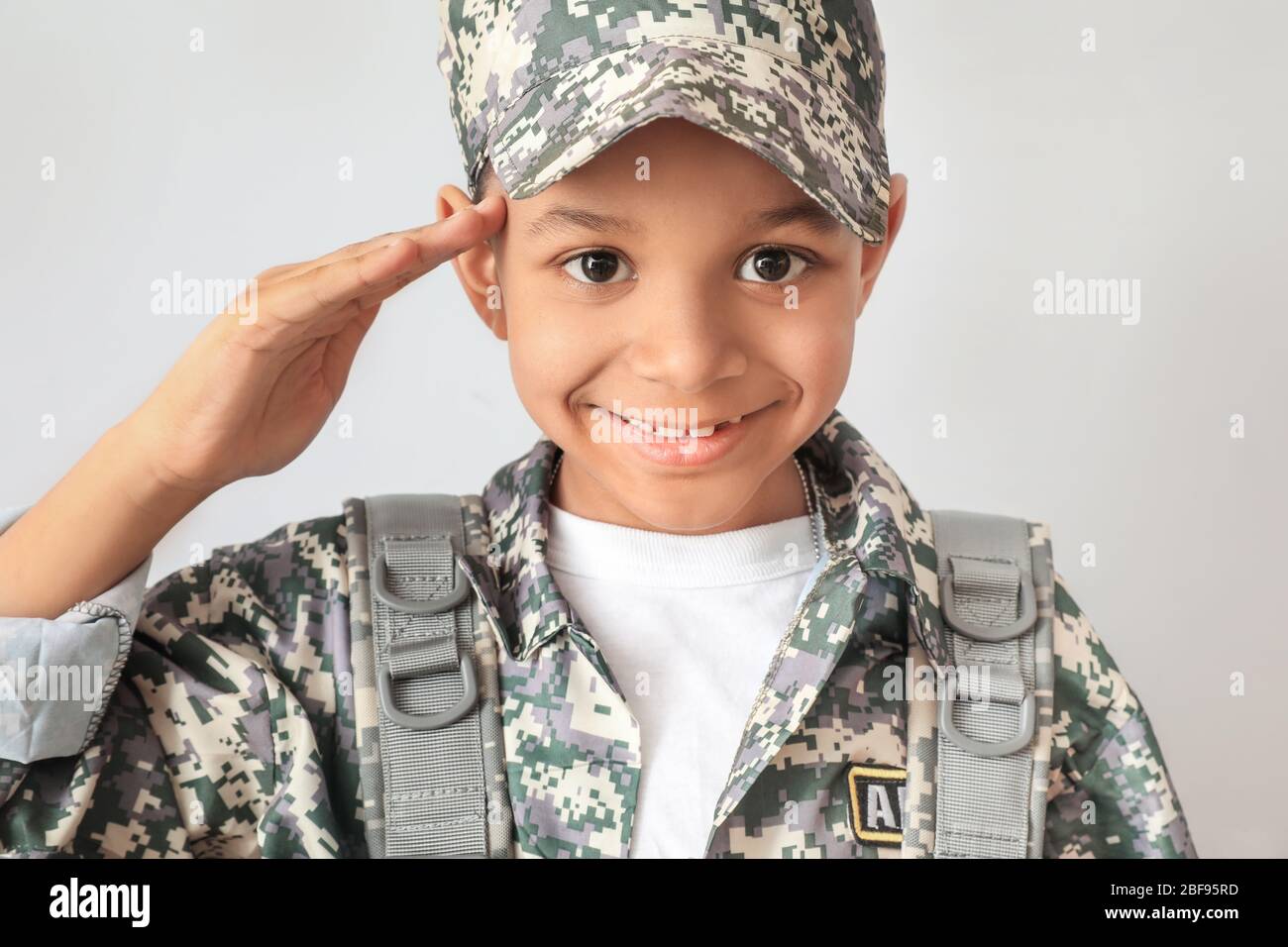 Little saluting African-American soldier on light background Stock ...
