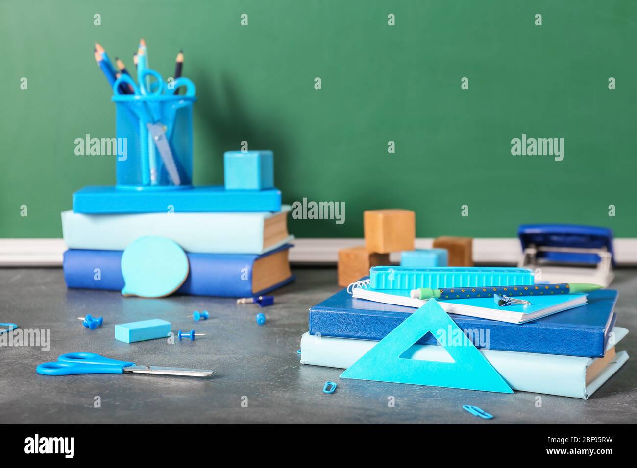 Books and stationery on table in classroom Stock Photo - Alamy