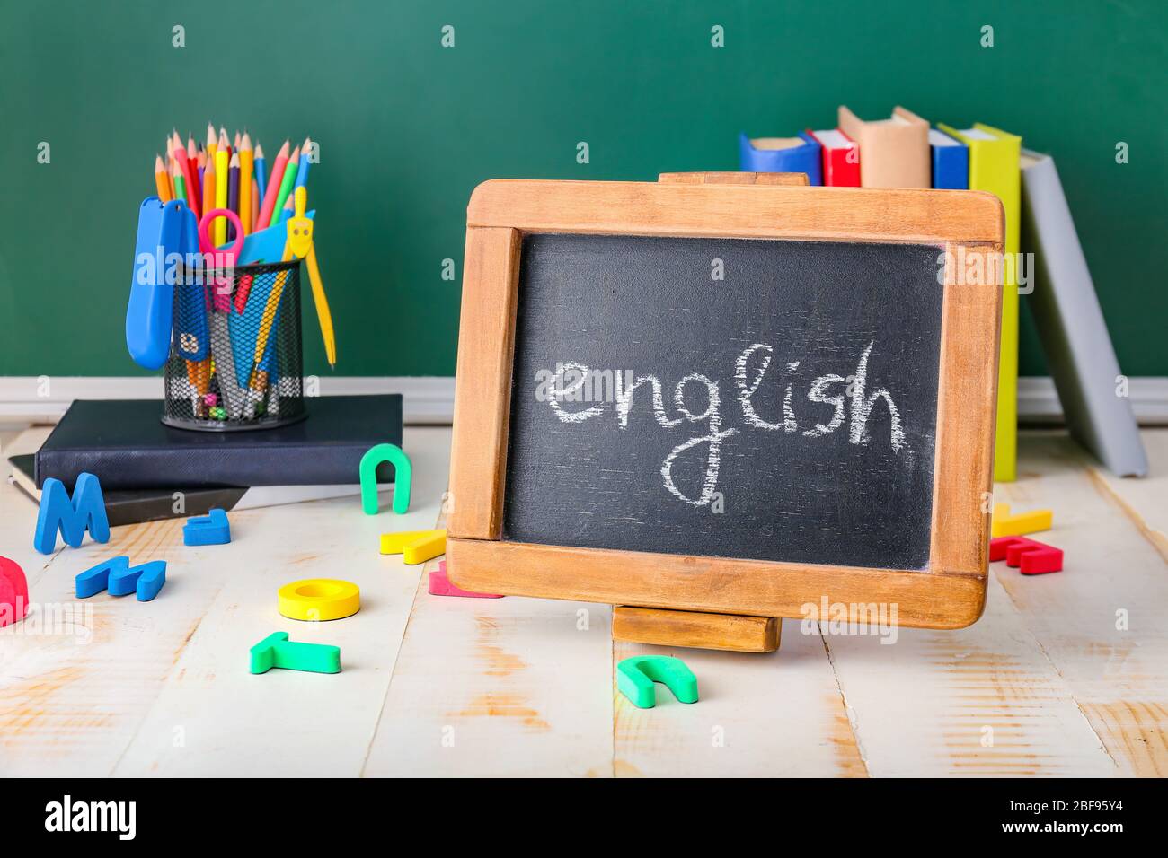 Chalkboard with text ENGLISH and stationery on table in classroom Stock ...
