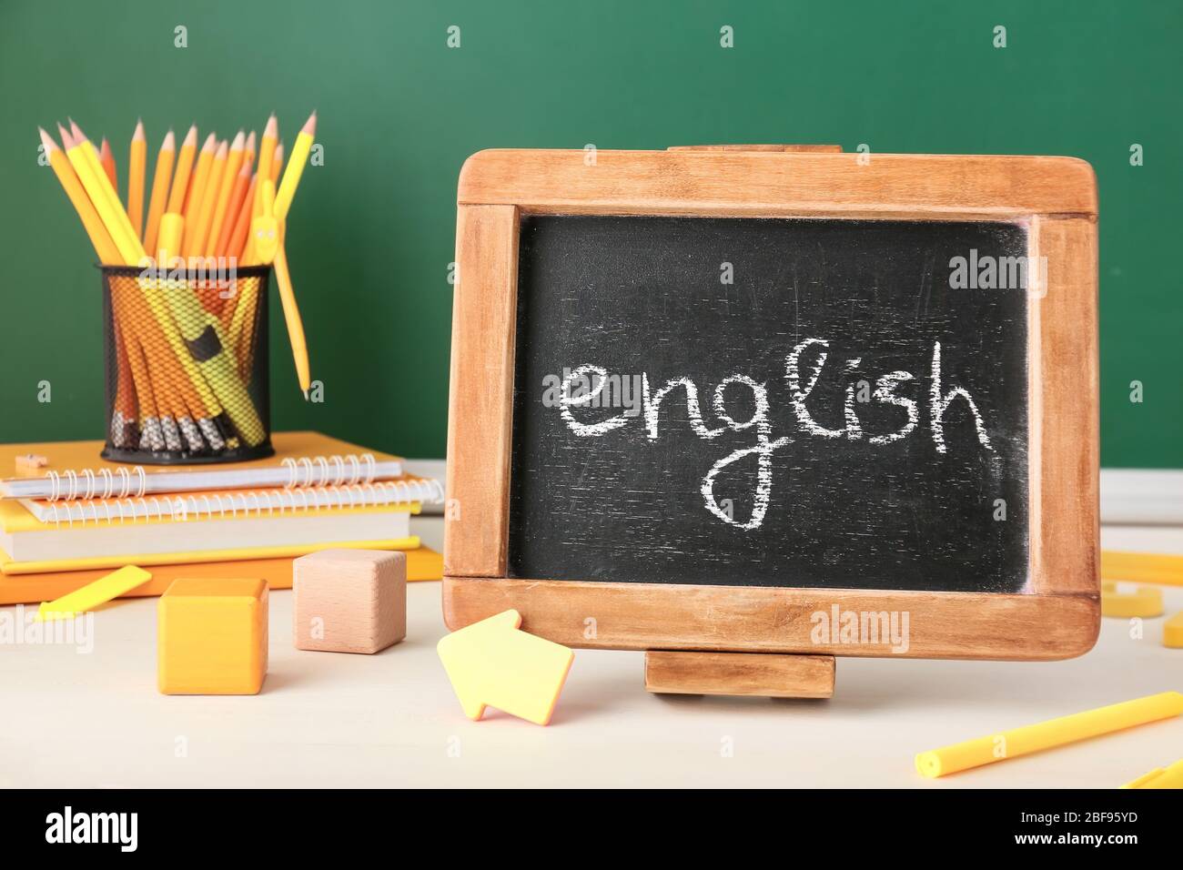 Chalkboard with text ENGLISH and stationery on table in classroom Stock ...