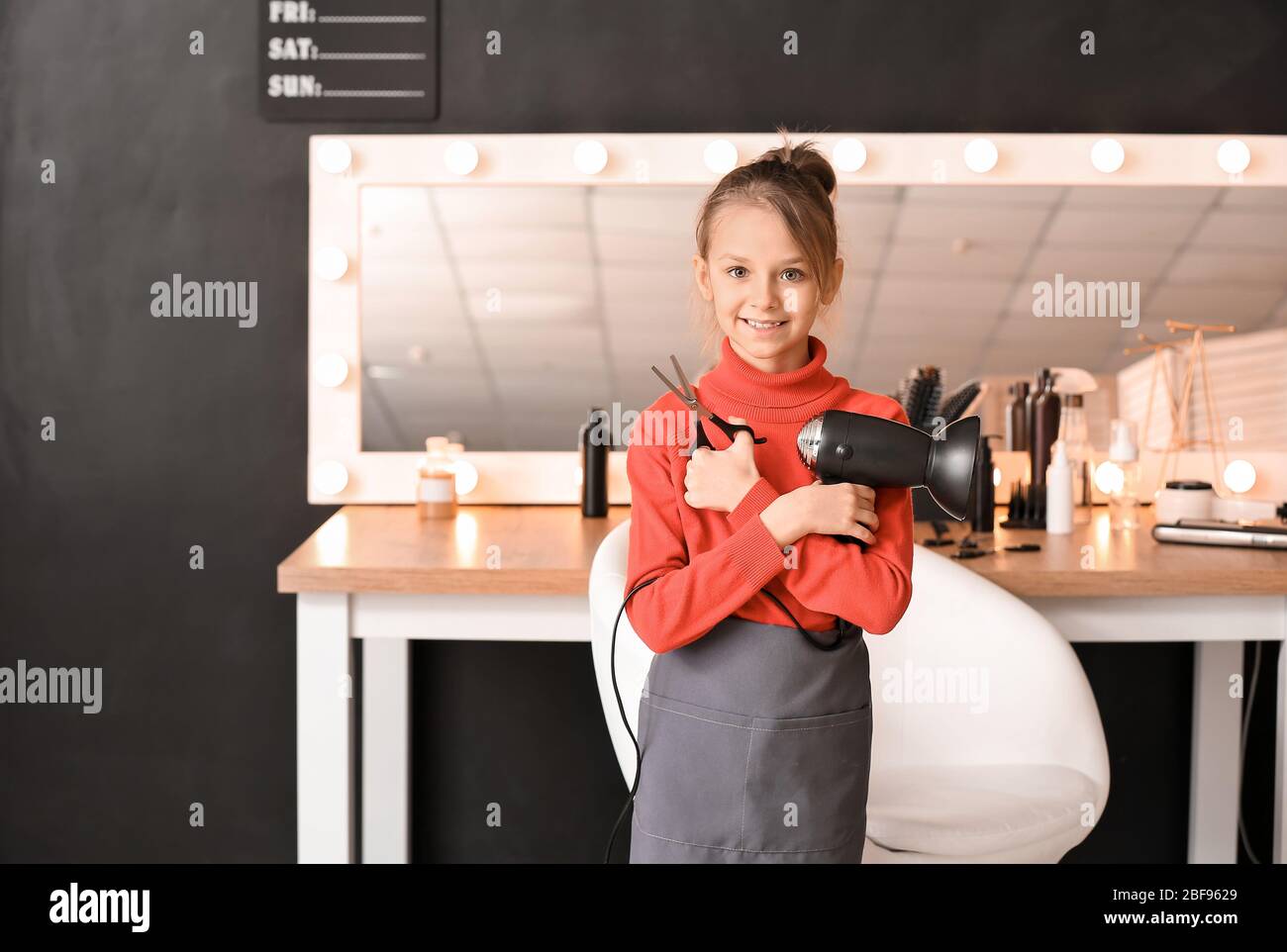Cute little hairdresser in beauty salon Stock Photo - Alamy