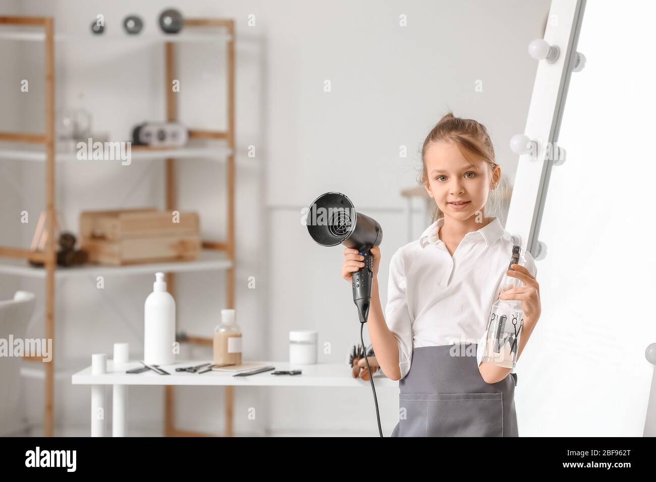 Cute little hairdresser in beauty salon Stock Photo - Alamy