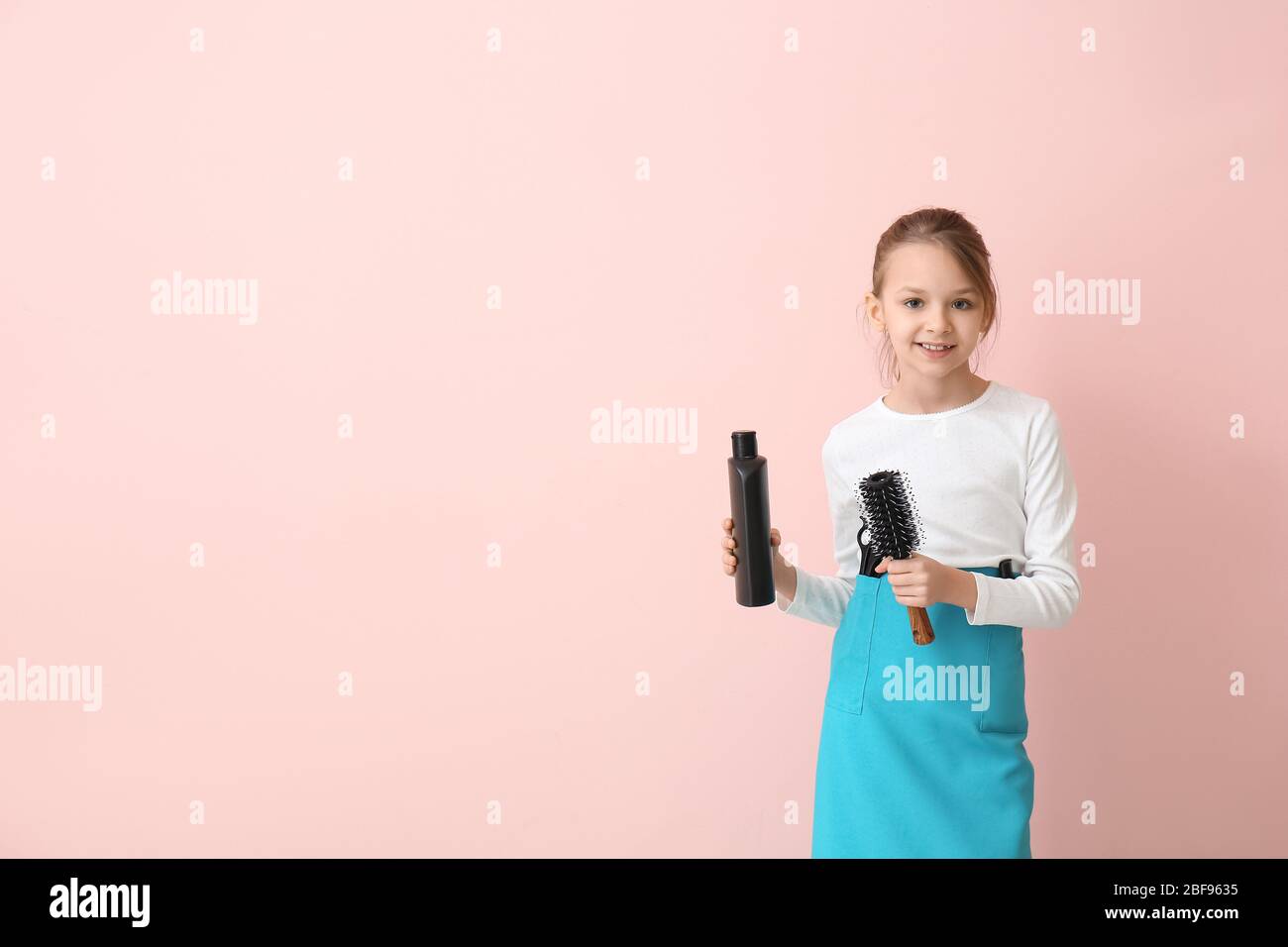 Cute little hairdresser on color background Stock Photo - Alamy
