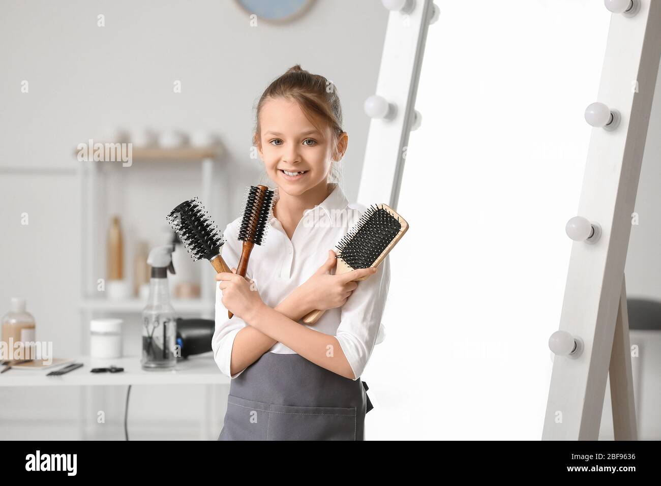 Cute little hairdresser in beauty salon Stock Photo - Alamy