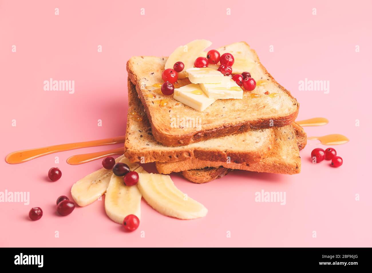Tasty toasted bread with honey, butter and fruits on color background ...