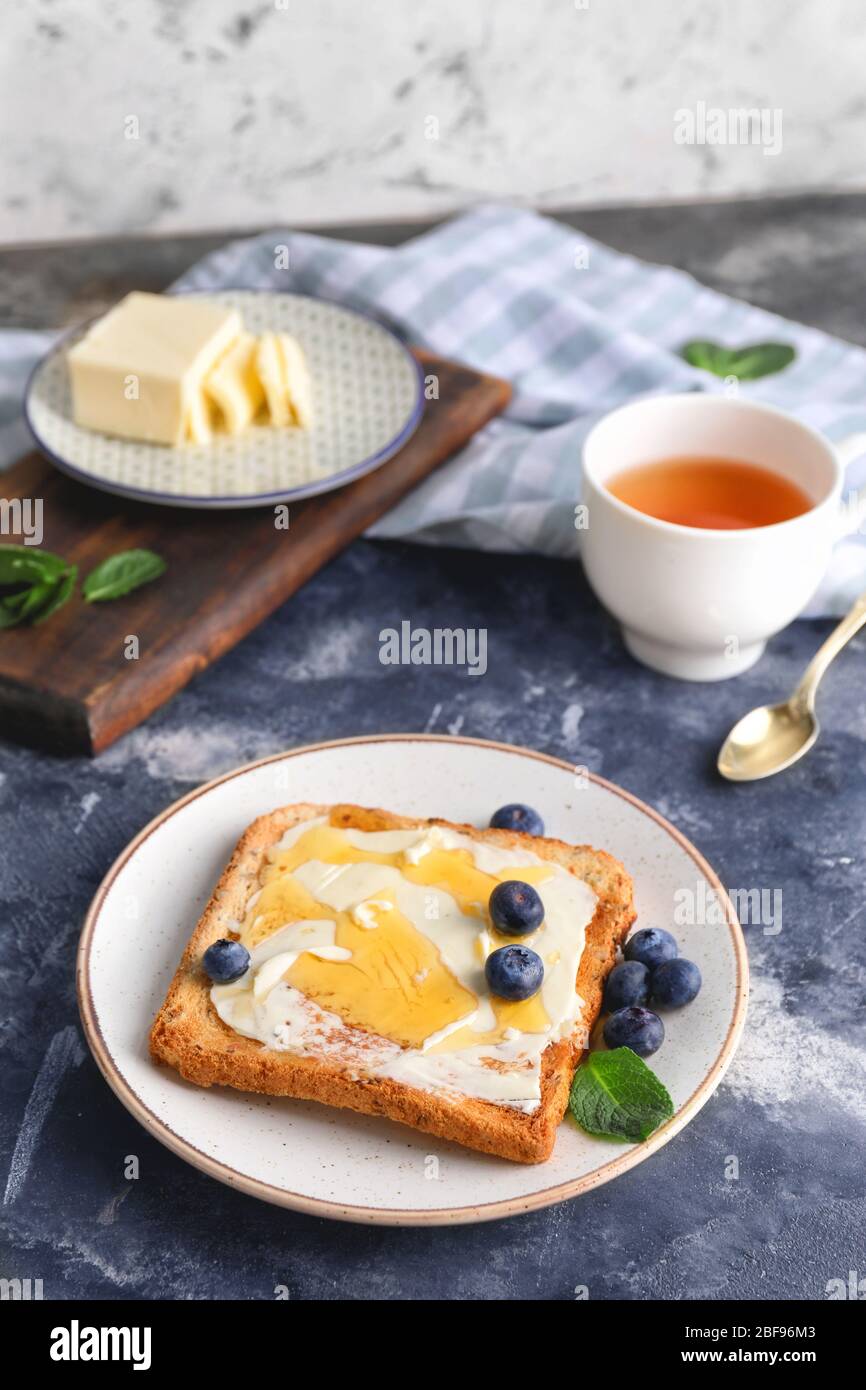 Tasty toasted bread with honey, butter and berries on table Stock Photo ...
