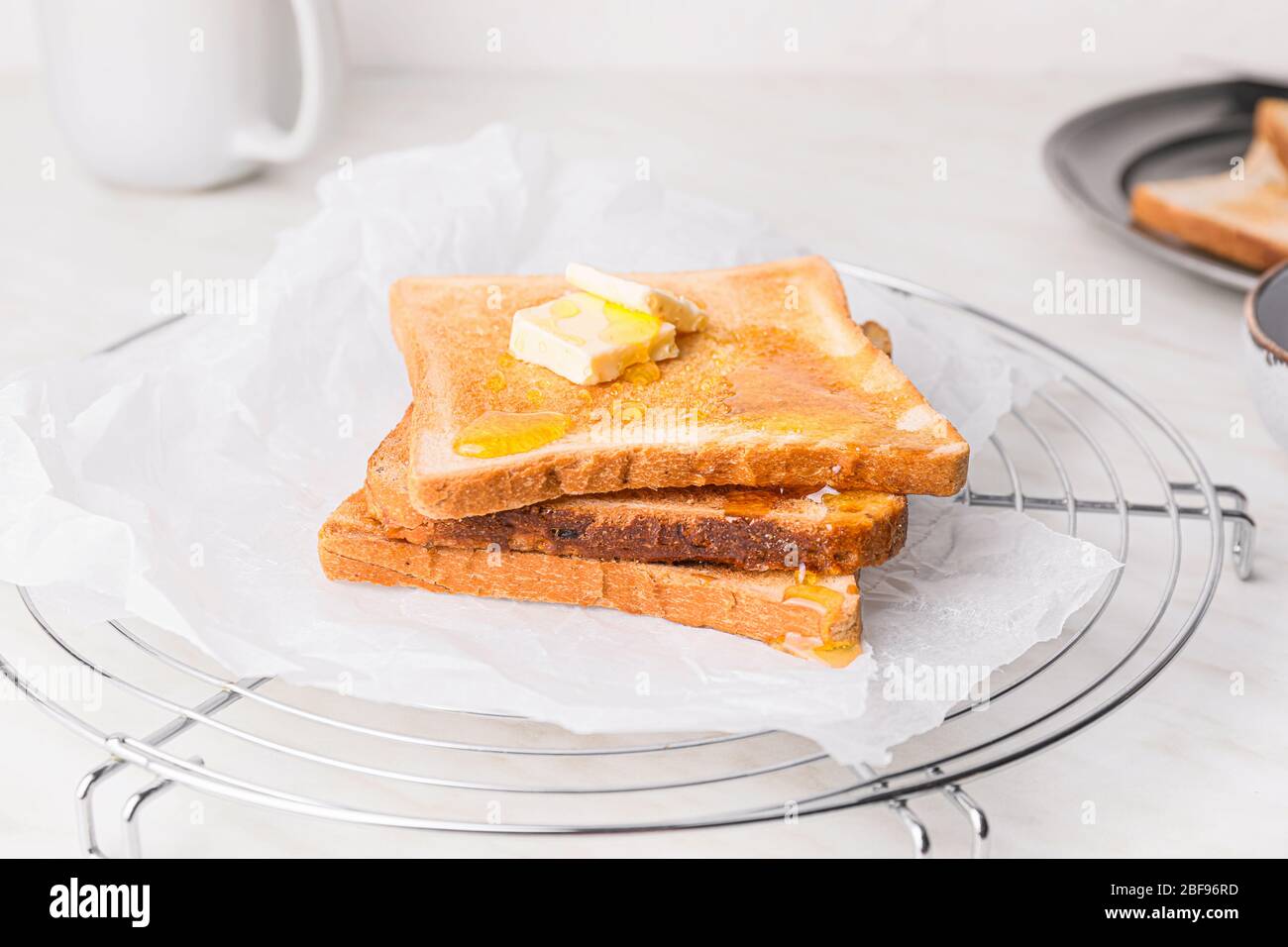 Tasty toasted bread with honey and butter on cooling rack Stock Photo ...