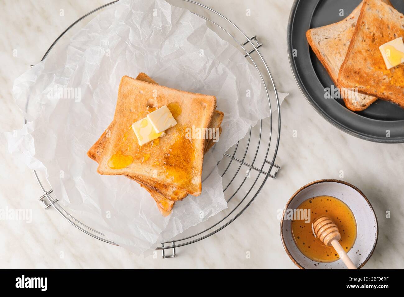 Tasty toasted bread with honey and butter on white background Stock ...