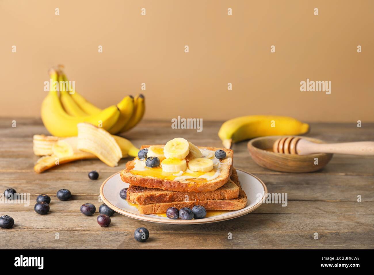 Tasty toasted bread with honey, butter and fruits on plate Stock Photo ...