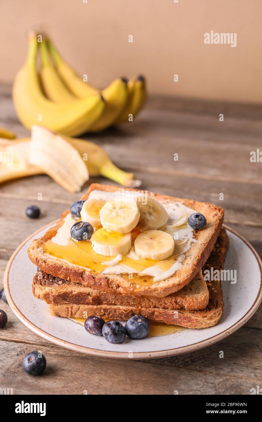 Tasty toasted bread with honey, butter and fruits on plate Stock Photo ...