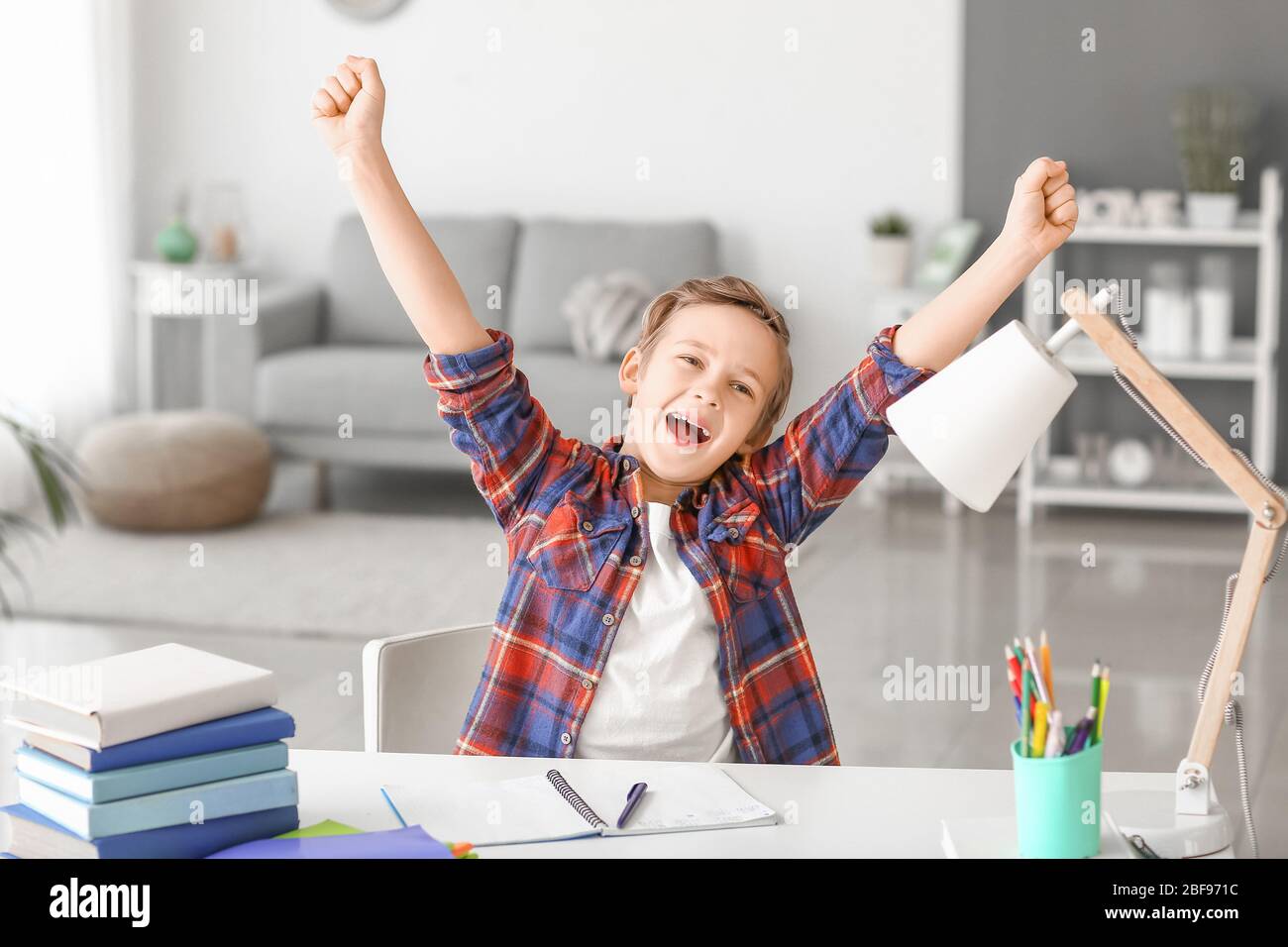Happy little boy with his homework done at table Stock Photo - Alamy