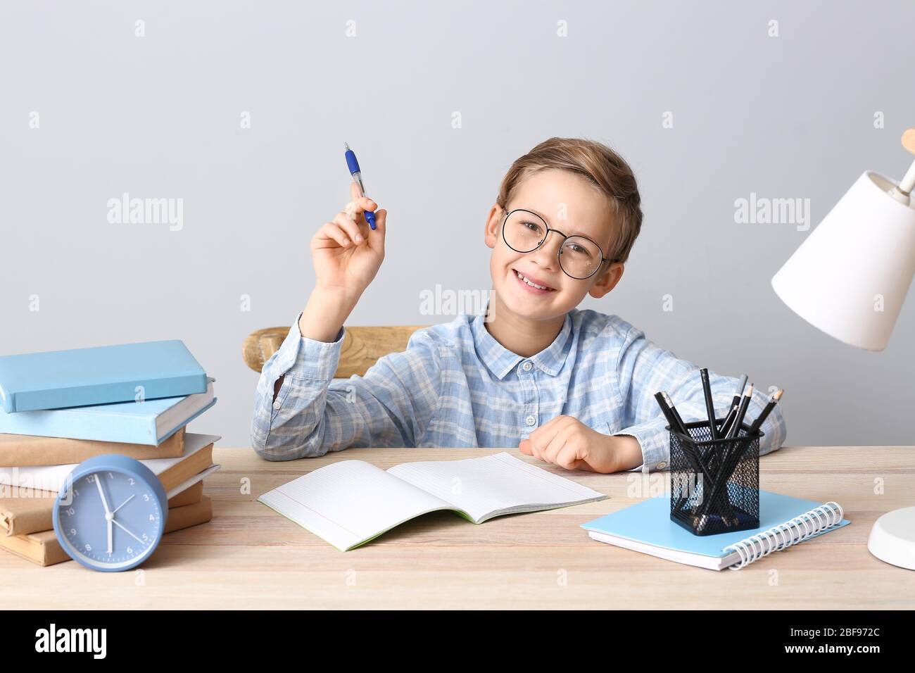 Cute little boy doing homework at table Stock Photo - Alamy