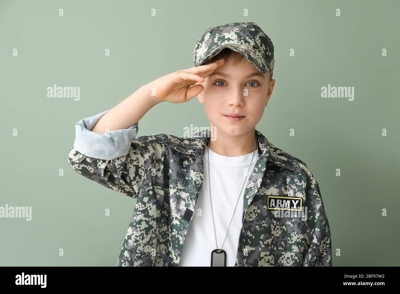 Cute saluting little soldier on color background Stock Photo - Alamy