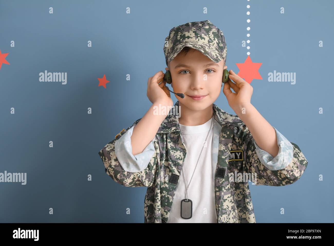 Cute little soldier with headset on color background Stock Photo - Alamy