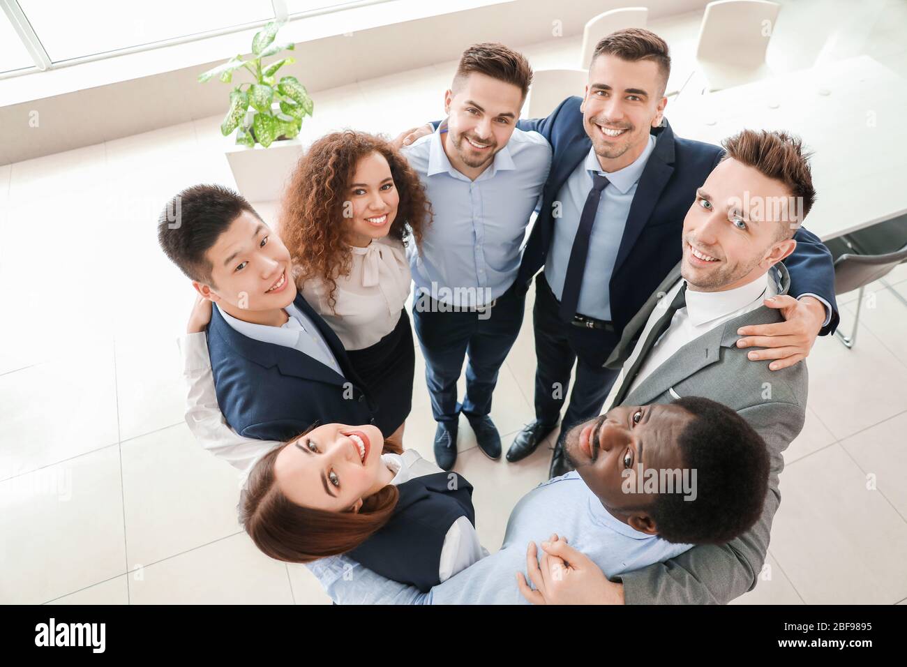 Group of business people hugging in office, top view. Unity concept ...