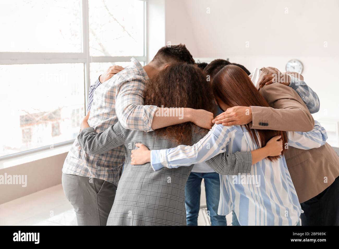 Group of people hugging indoors. Unity concept Stock Photo - Alamy