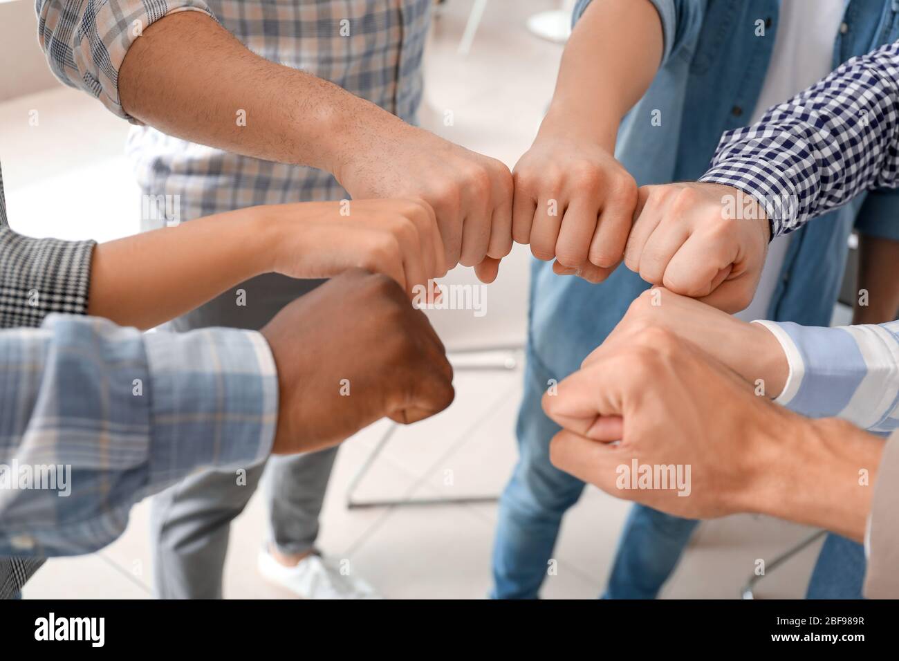 Group of people putting hands together indoors. Unity concept Stock ...