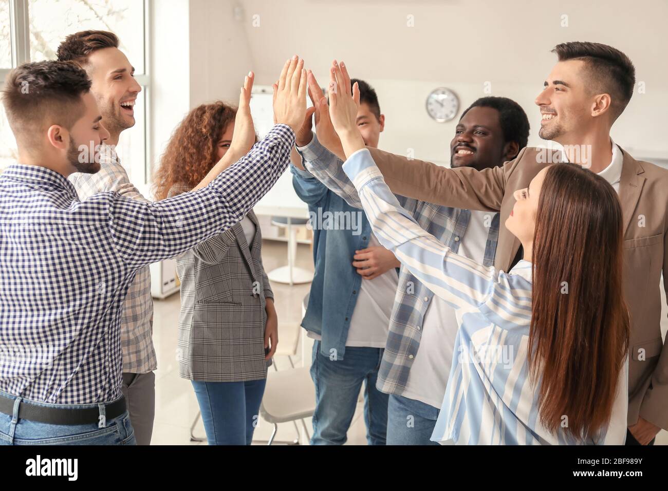 Group of people putting hands together indoors. Unity concept Stock ...