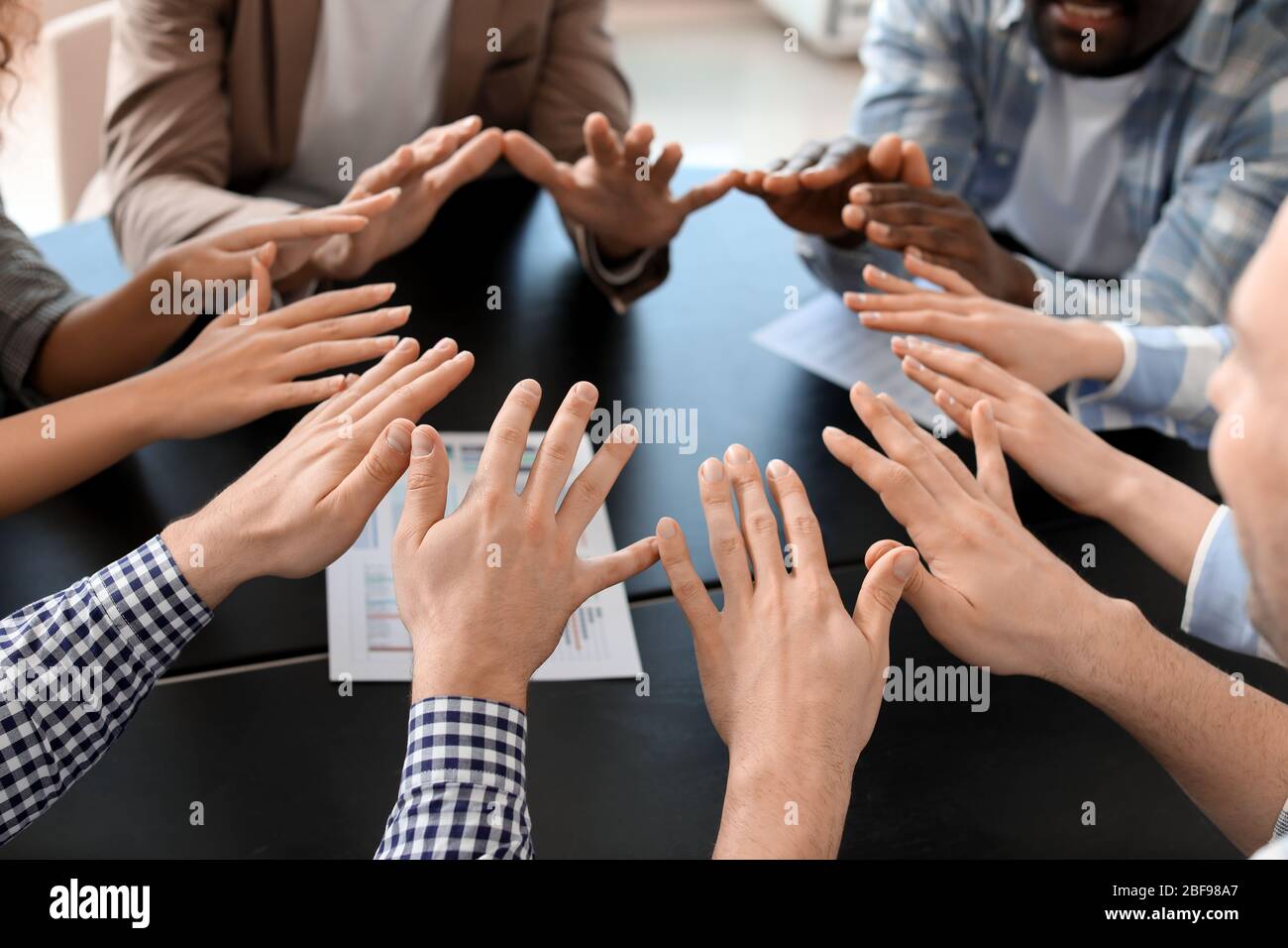 Group of people putting hands together indoors. Unity concept Stock ...