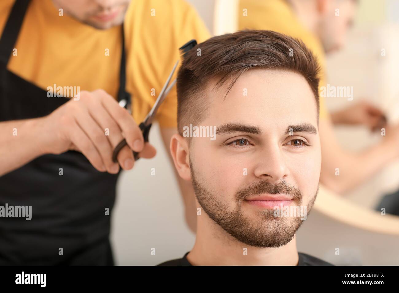 Male hairdresser working with client in salon Stock Photo - Alamy