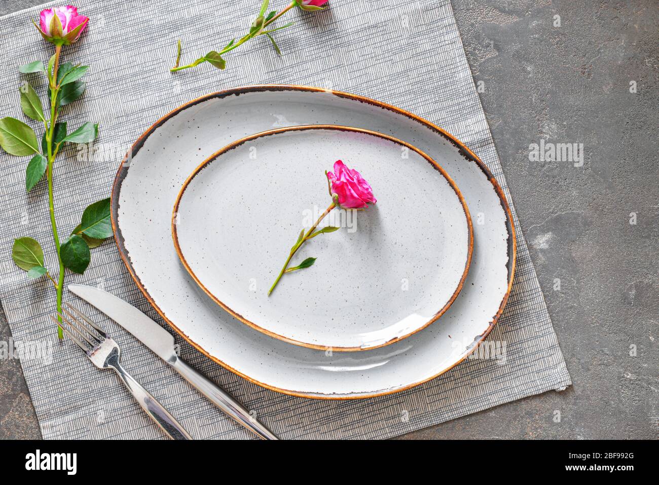 Beautiful simple table setting on grey background Stock Photo - Alamy