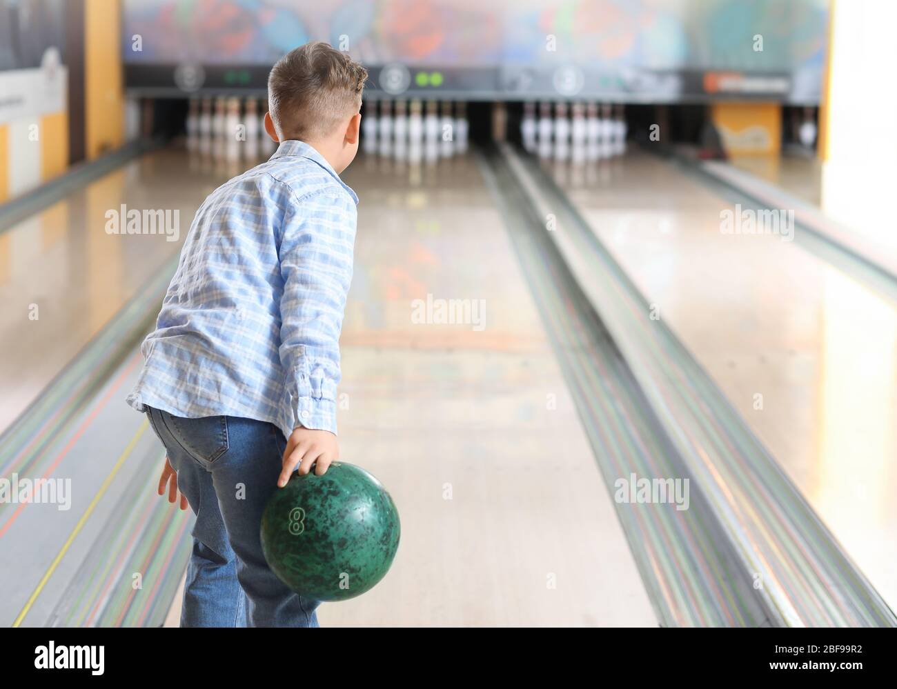Little boy playing bowling in club Stock Photo - Alamy