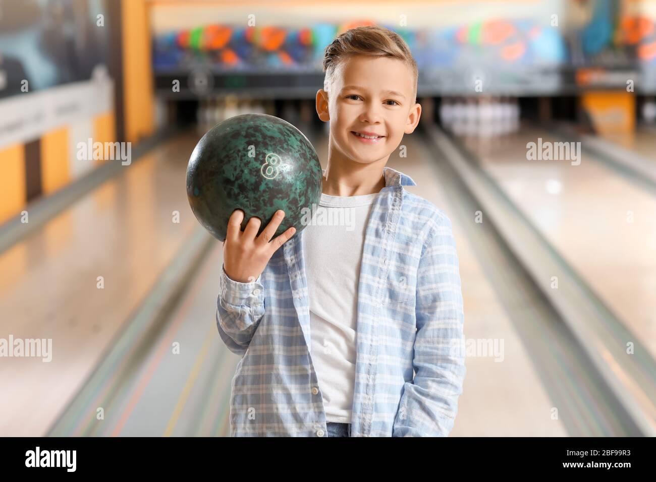 Little boy playing bowling in club Stock Photo - Alamy