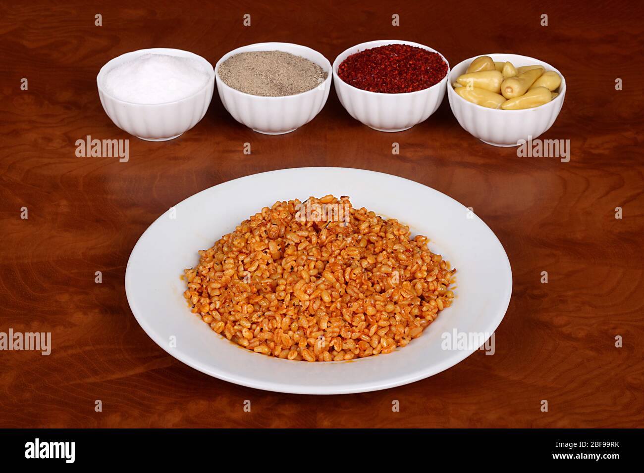 Boiled bulgur with delicious tomato sauce ready to serve on a white ...