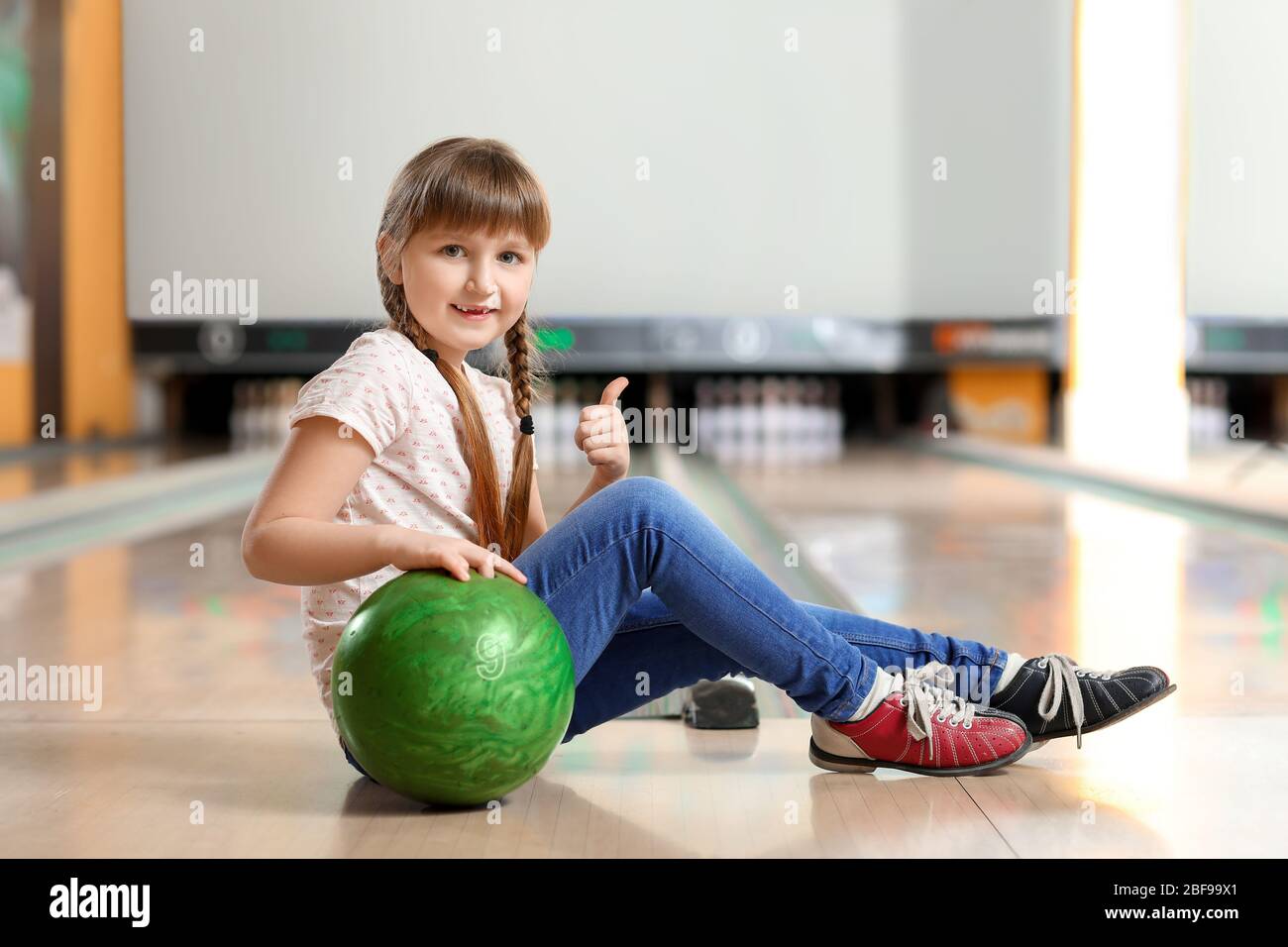 Little girl playing bowling in club Stock Photo - Alamy