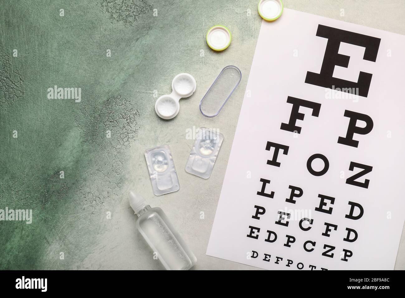 Containers for contact lenses, solution and eye test chart on color ...