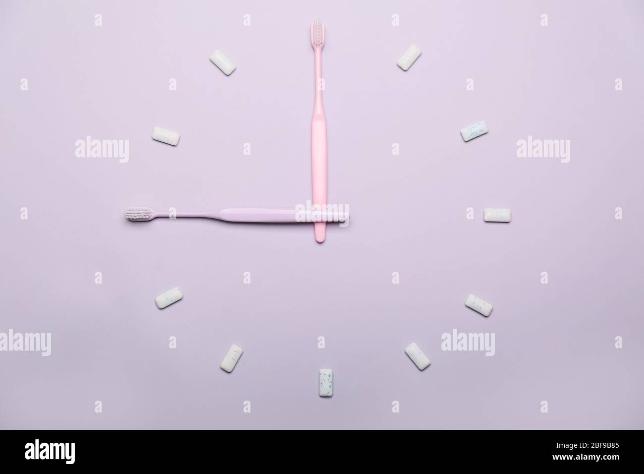 Clock made of tooth brushes and chewing gum on grey background Stock ...