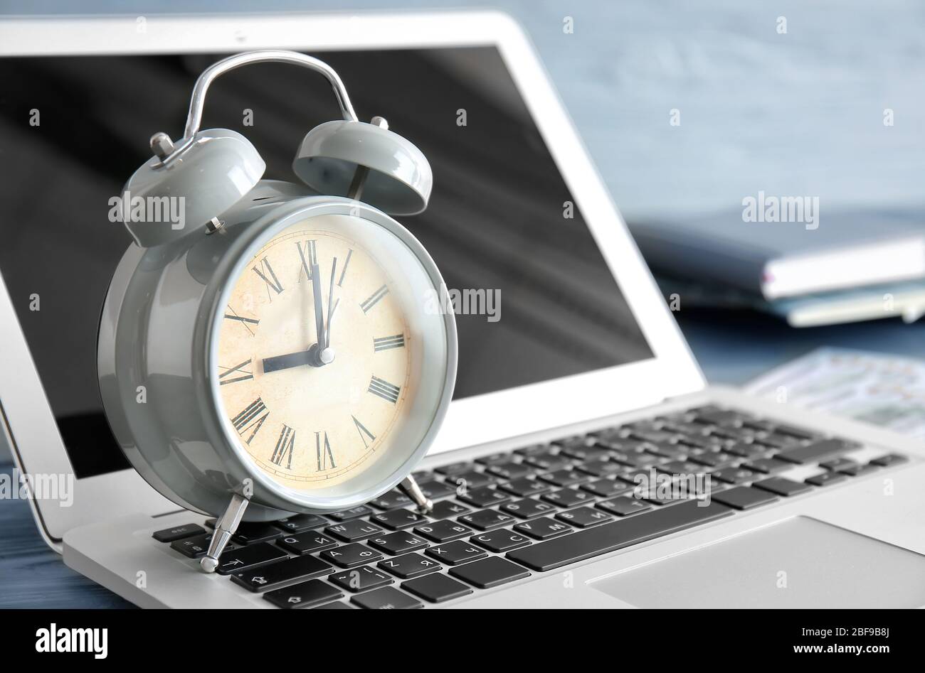 Alarm clock with laptop on table, closeup. Time management concept ...