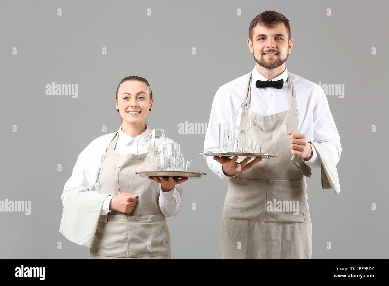 Portrait of waiters on grey background Stock Photo - Alamy