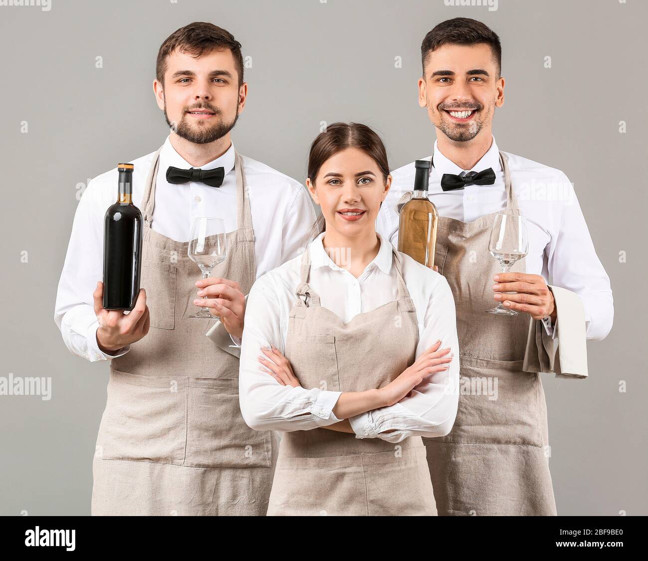 Portrait of waiters on grey background Stock Photo - Alamy
