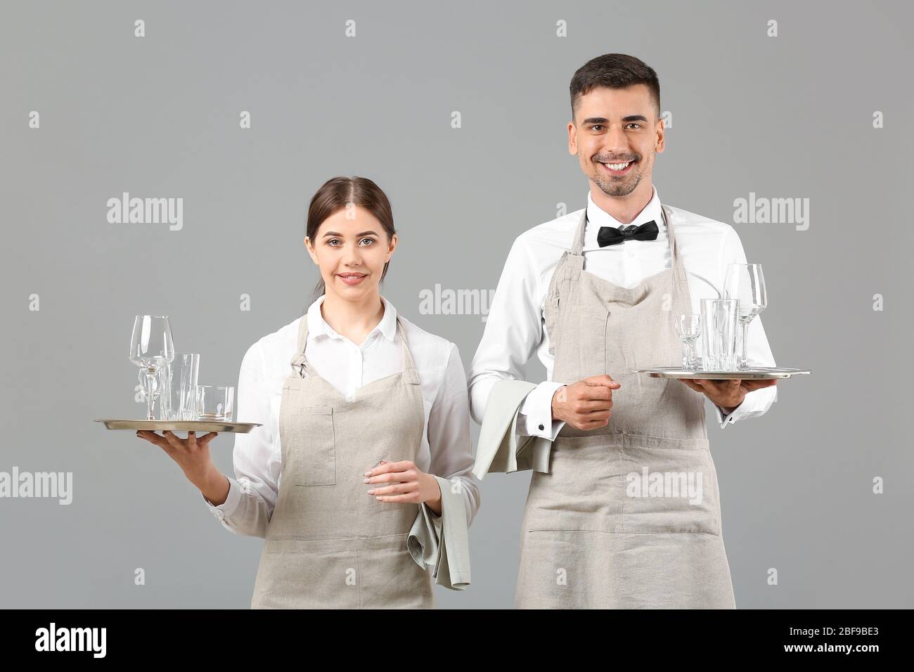 Portrait of waiters on grey background Stock Photo - Alamy