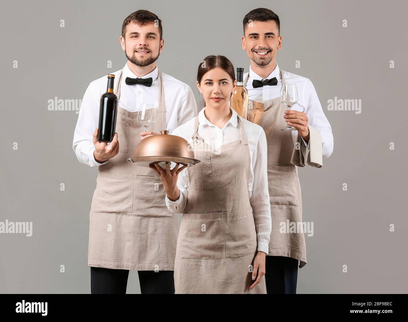 Portrait of waiters on grey background Stock Photo - Alamy