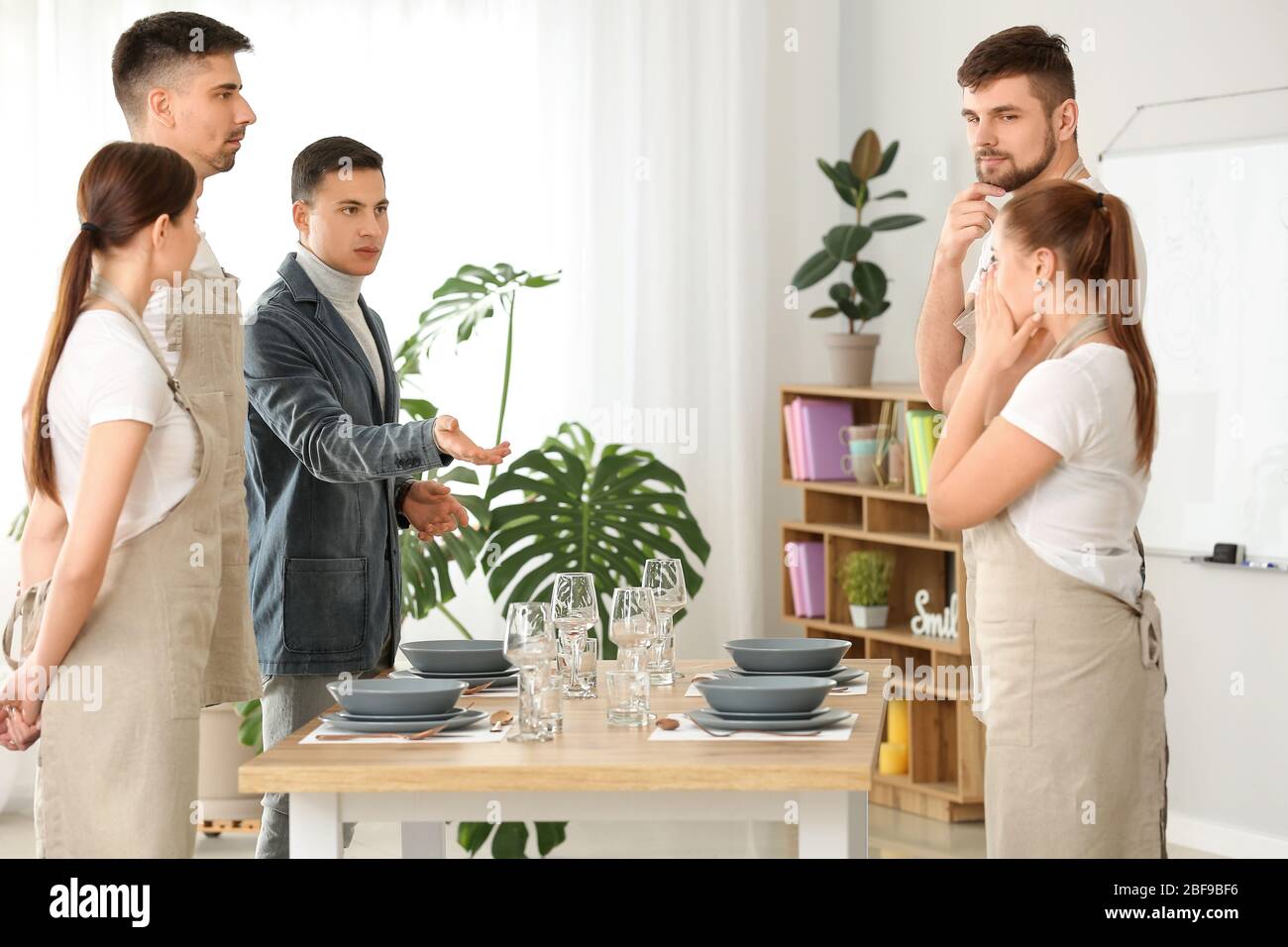 Young people attending professional waiter courses Stock Photo - Alamy