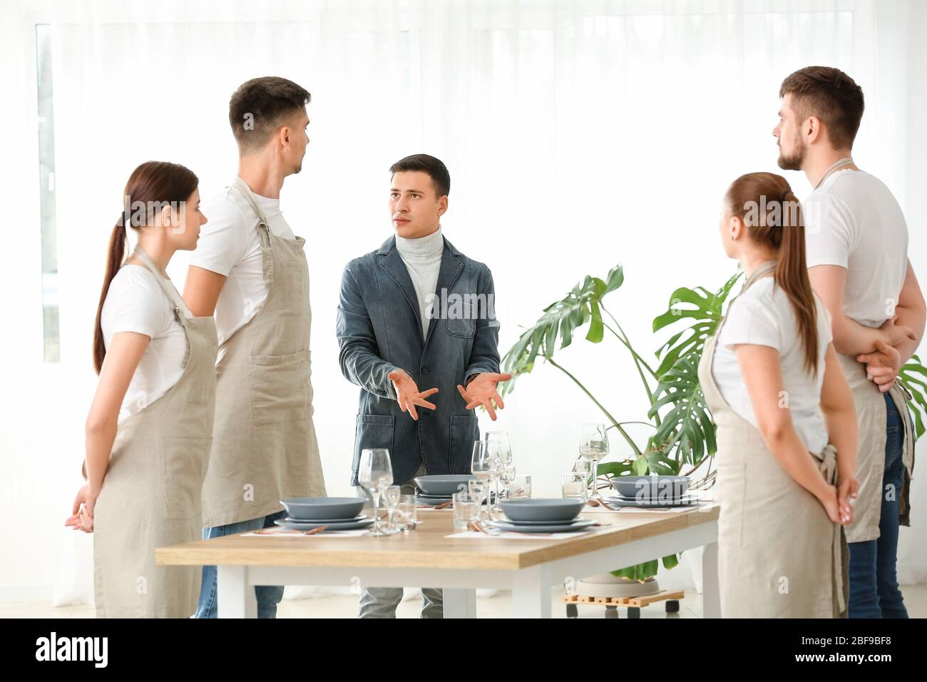 Young people attending professional waiter courses Stock Photo - Alamy