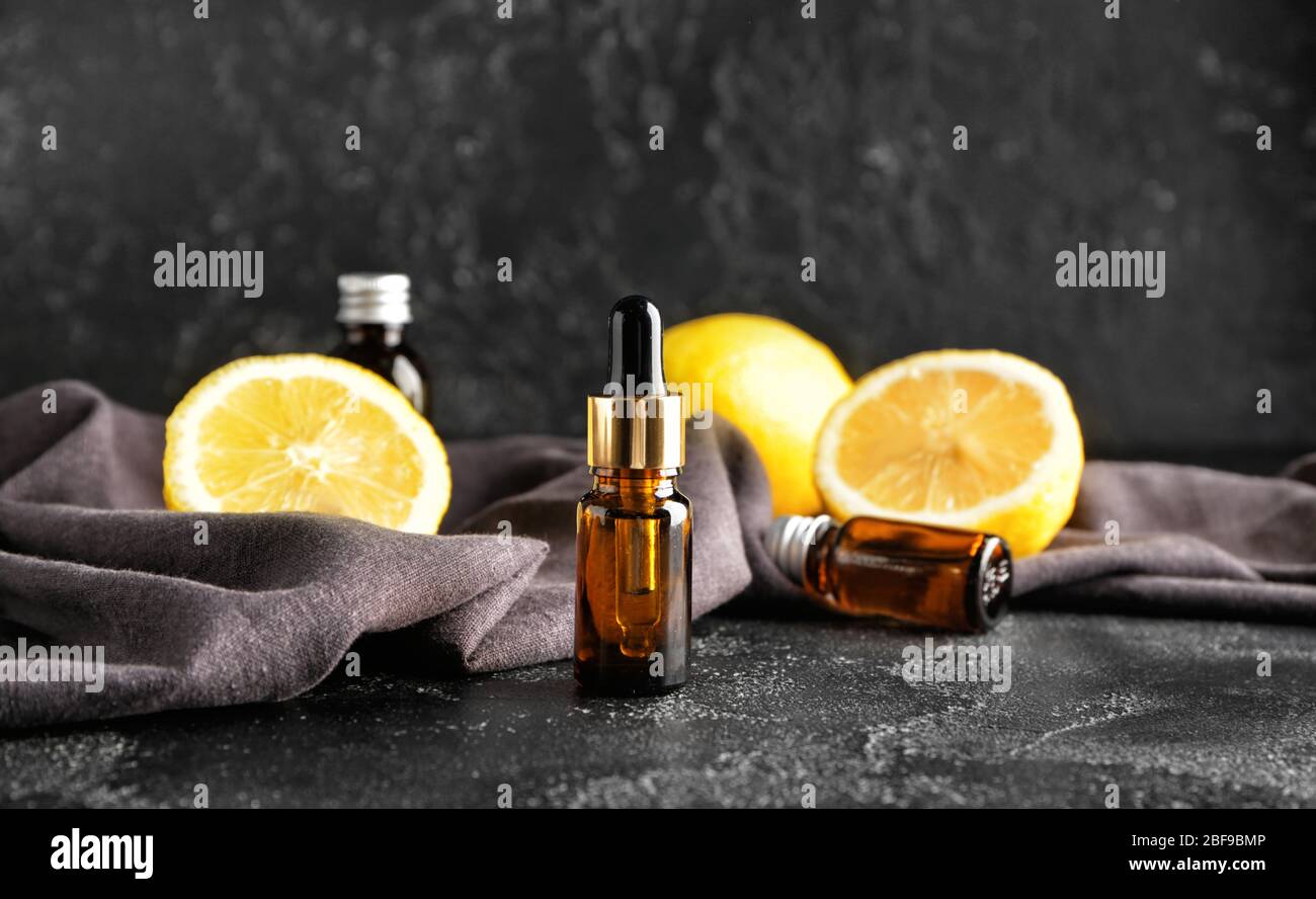 Bottles of lemon essential oil on table Stock Photo - Alamy