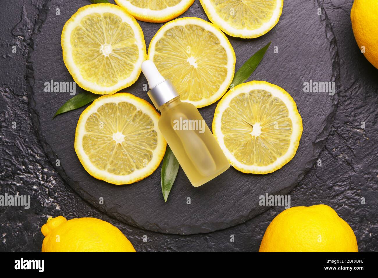 Composition with lemon essential oil on dark background Stock Photo - Alamy