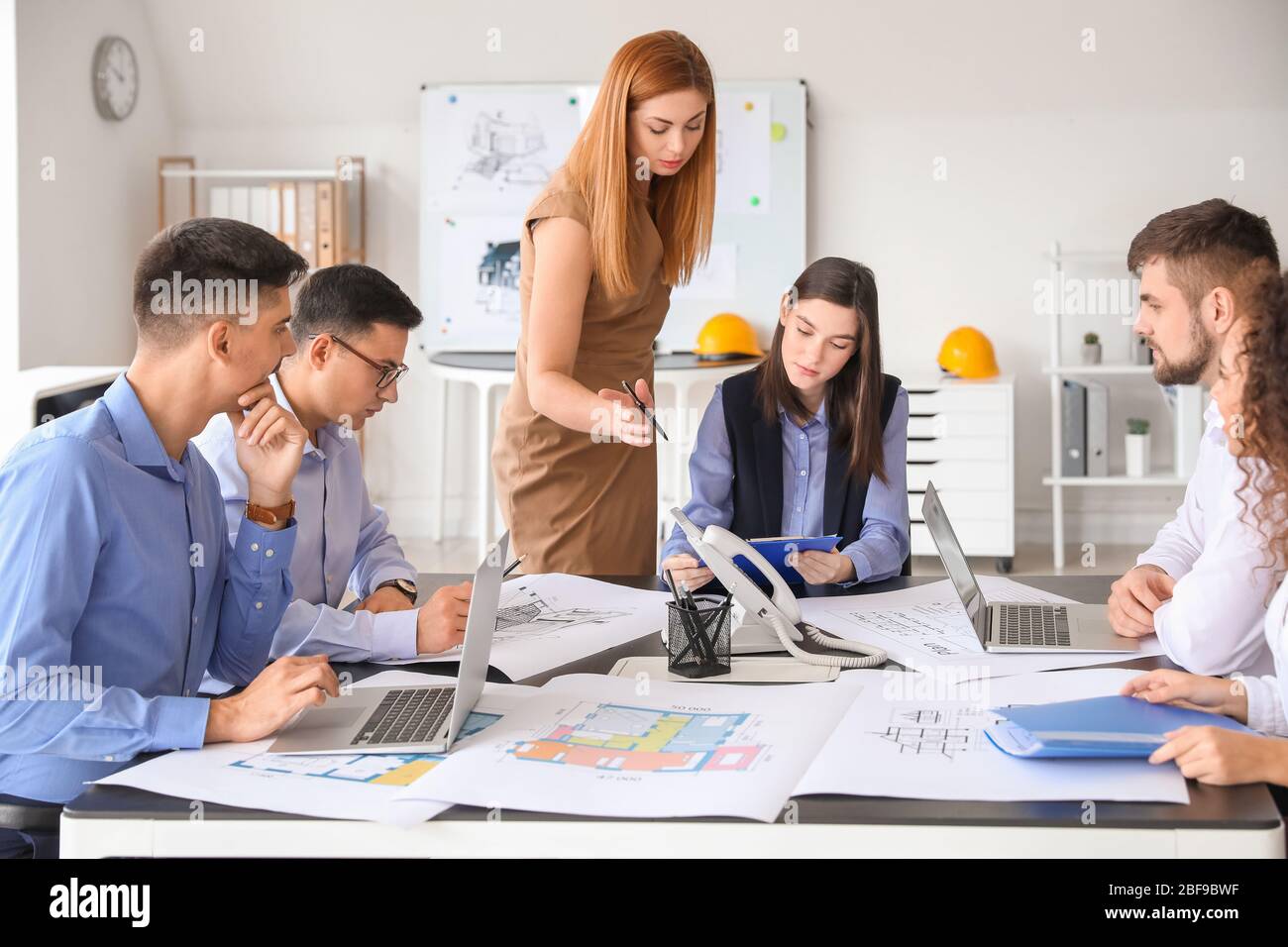 Architect teaching young people in office Stock Photo - Alamy