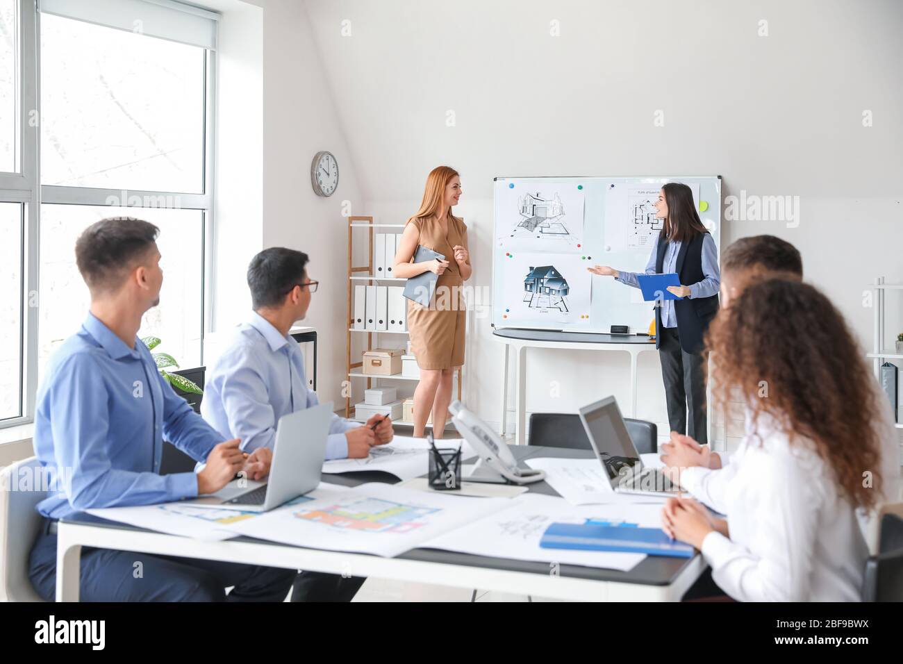 Architects teaching young people in office Stock Photo - Alamy