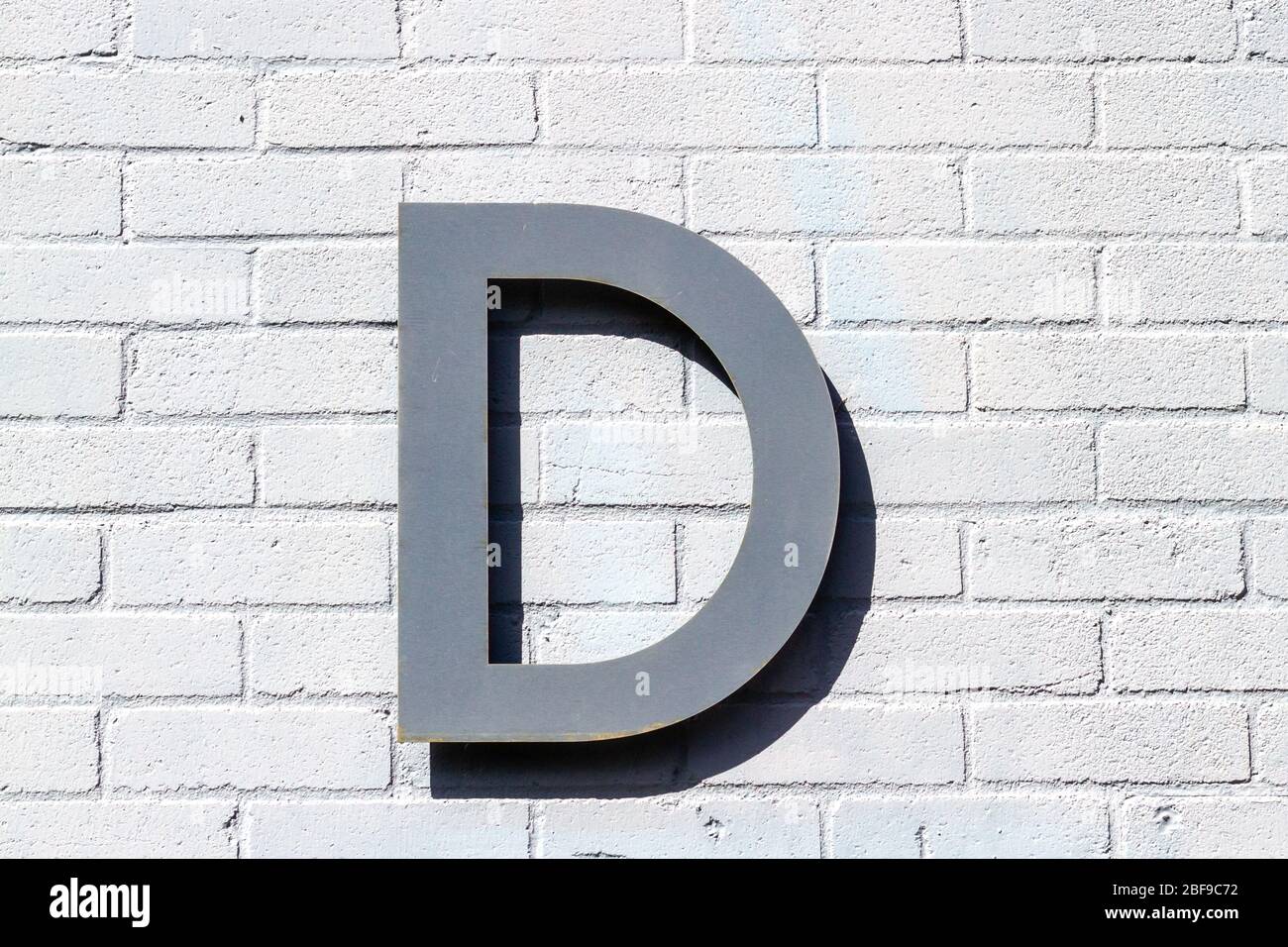 The letter D as a capital letter on a white brick wall Stock Photo - Alamy