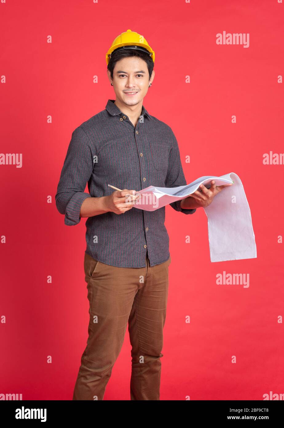 Young handsome asian man in casual dress with yellow hardhat hand ...