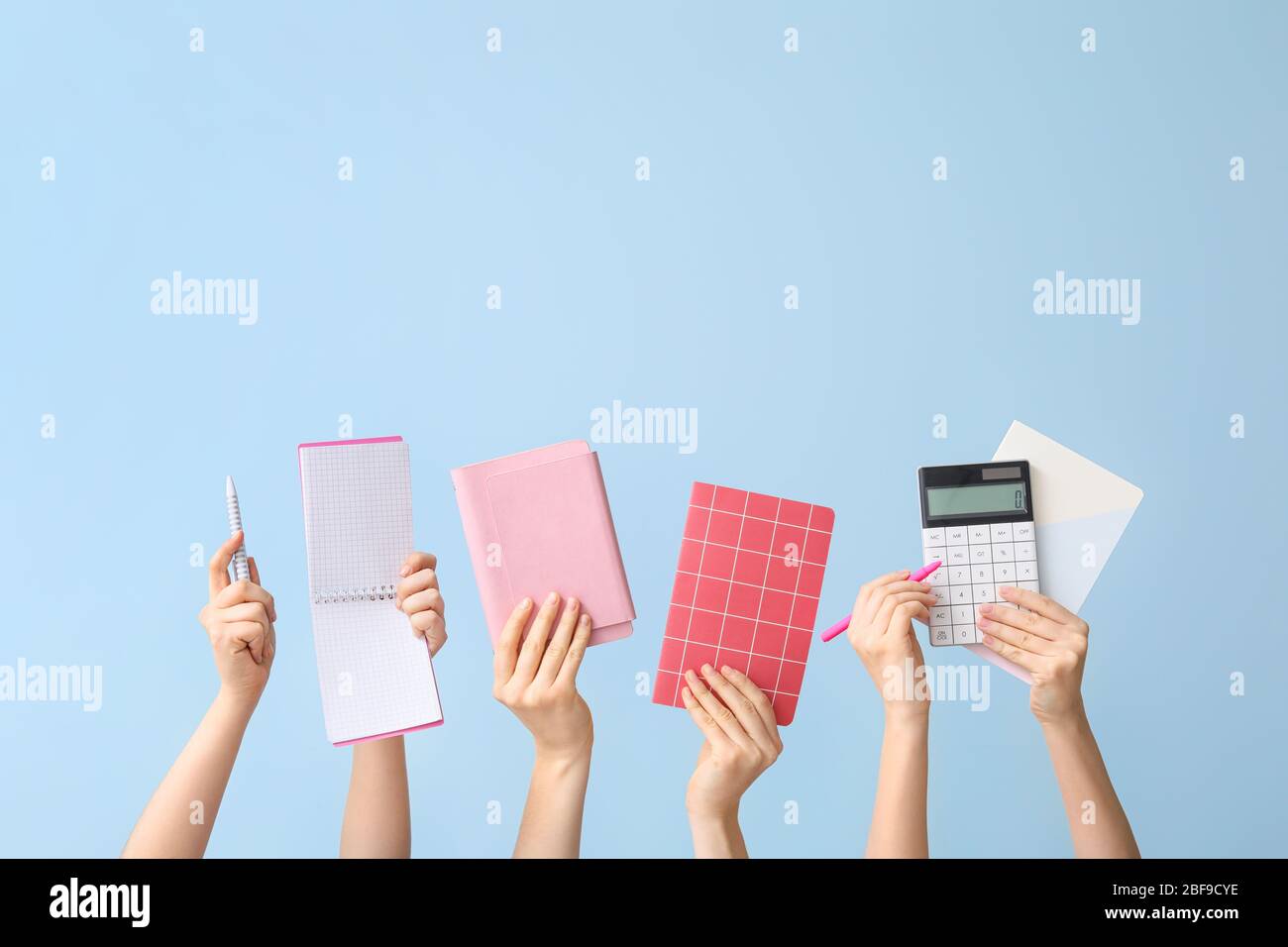 Many hands with school supplies on color background Stock Photo - Alamy