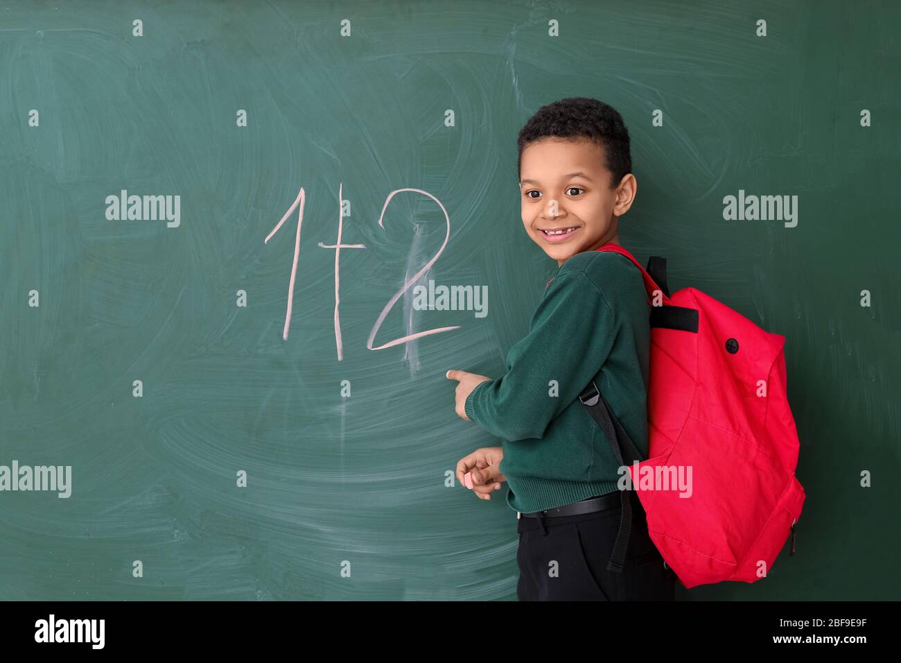 Cute African-American schoolboy near blackboard in classroom Stock ...