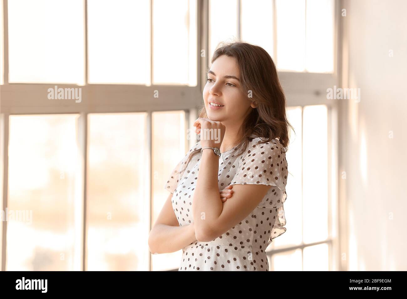 Beautiful young girl near window at home Stock Photo - Alamy